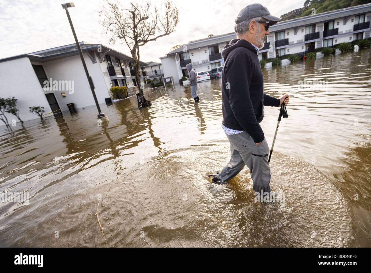 A man walks past a Holiday Inn Express that was flooded by the king ...