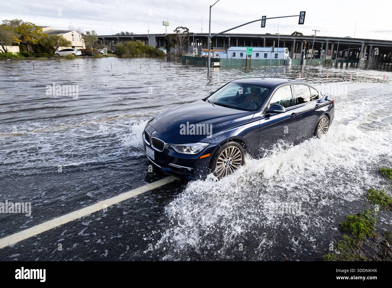A car drives through flooded streets caused by king tides Friday, Jan ...