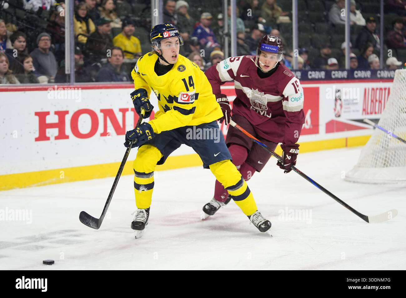 Sweden forward Linus Eriksson (14) skates with the puck as Latvia ...