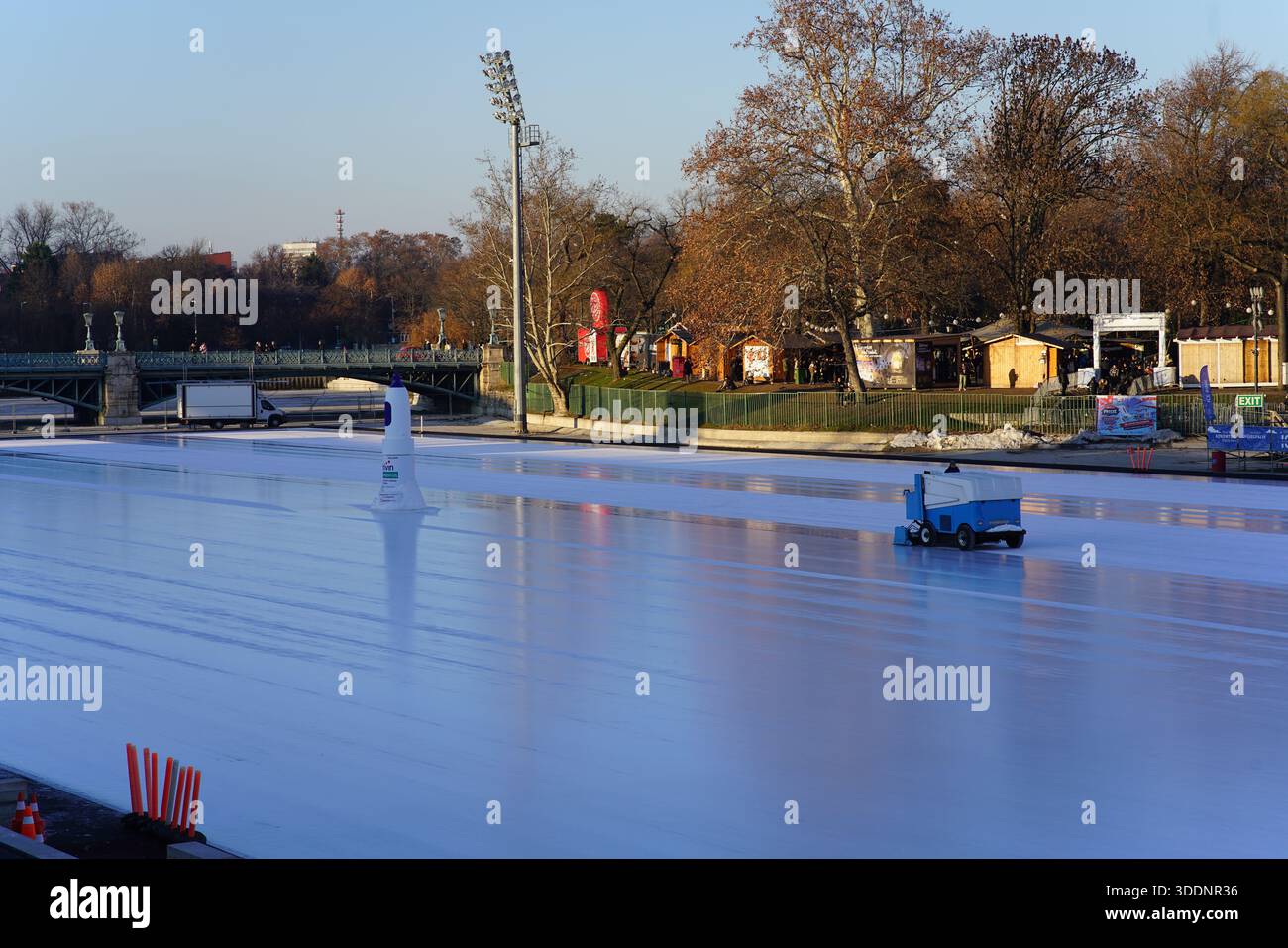 Center marker on an outdoor ice rink with winter fairground stalls and ...
