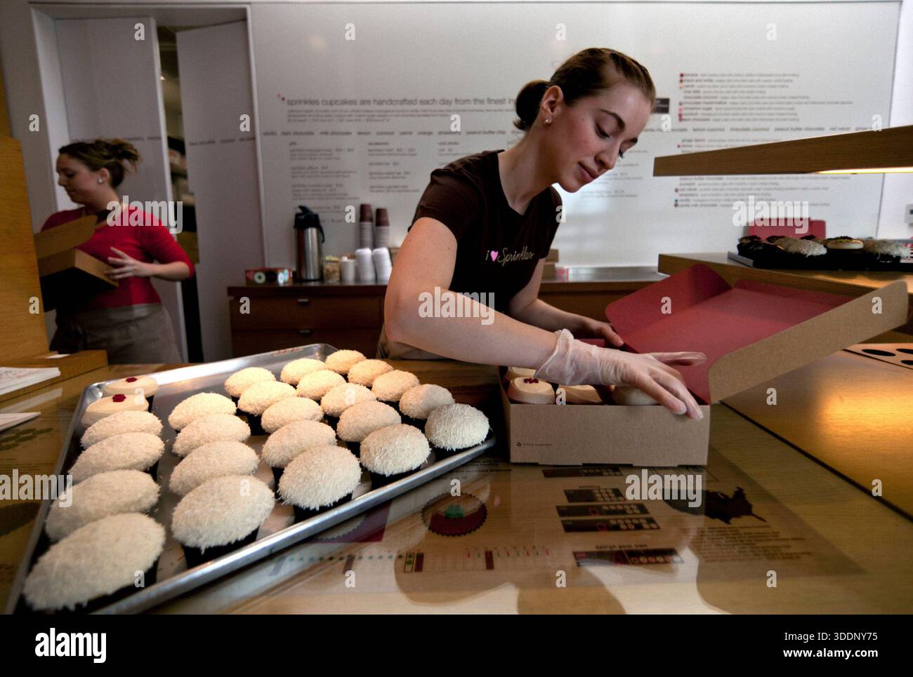 FILE - Sara Cebulski arranges a custom box of cupcakes at Sprinkles ...