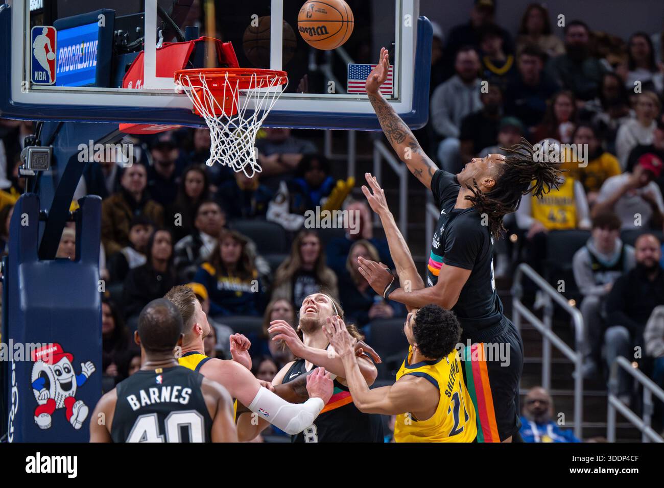 San Antonio Spurs guard Stephon Castle, right, tips a rebound in to ...