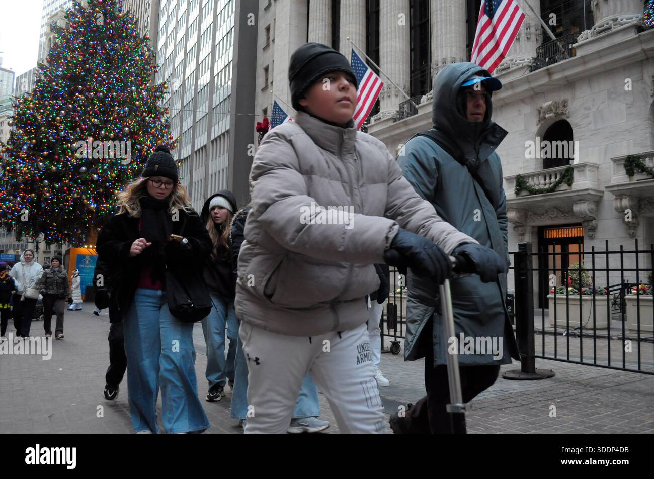 A person rides a scooter past the New York Stock Exchange, which is ...