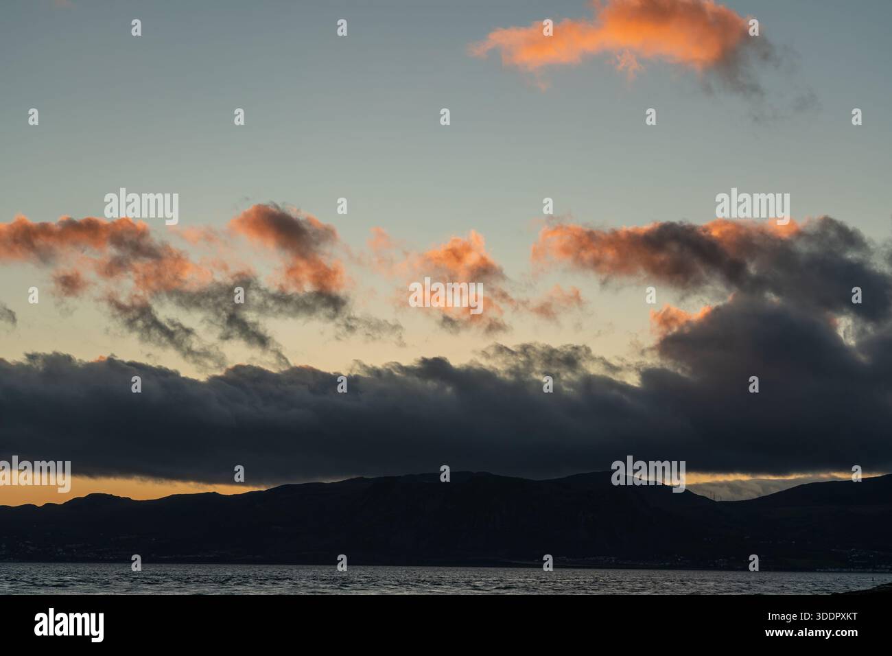 Sunrise over the Carneddau mountains beneath layered clouds Stock Photo ...