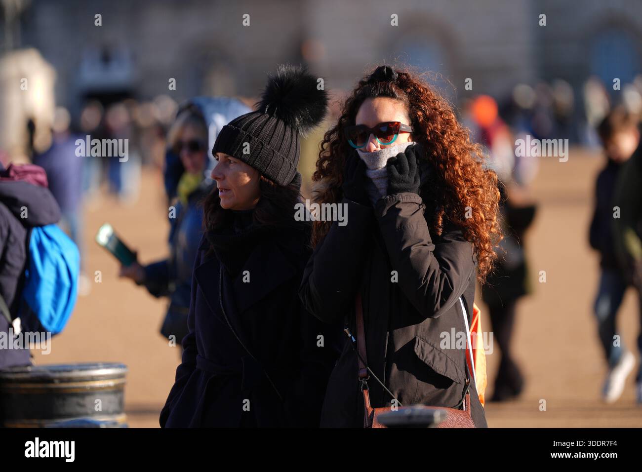 People wrap up warm as they walk in Horse Guards, London. Bitterly cold ...