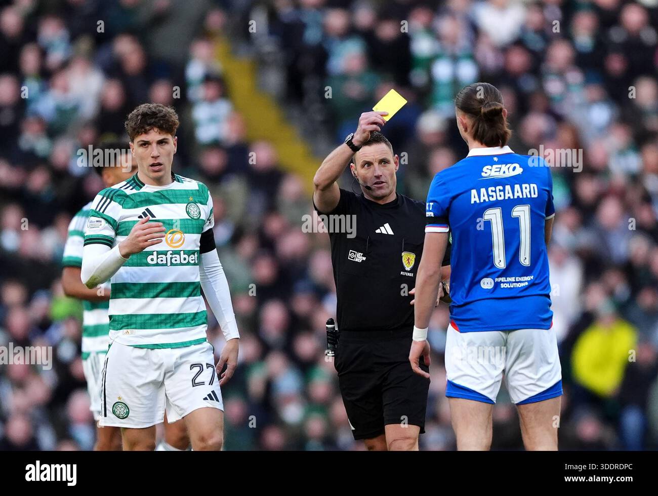 Referee Steven McLean shows a yellow card to Rangers' Thelo Aasgaard ...