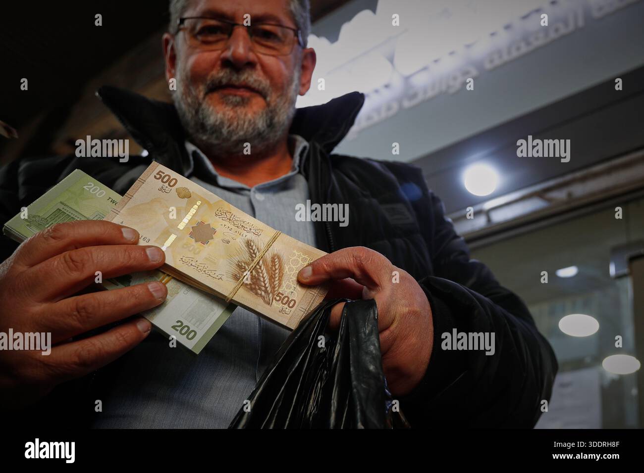 A man displays 500, and 200-pound notes from Syria's newly circulating ...