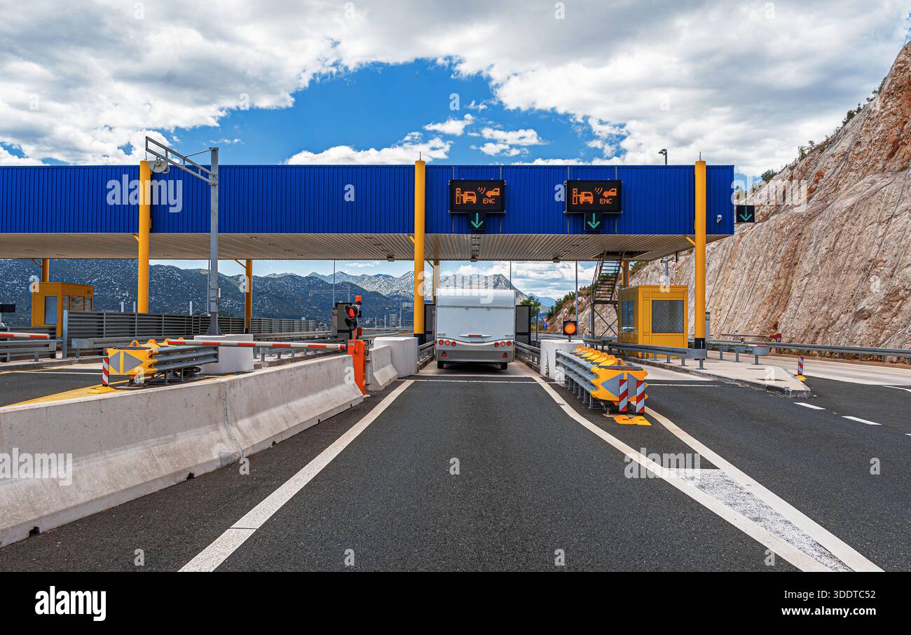 A white caravan trailer passes through an electronic toll collection ...