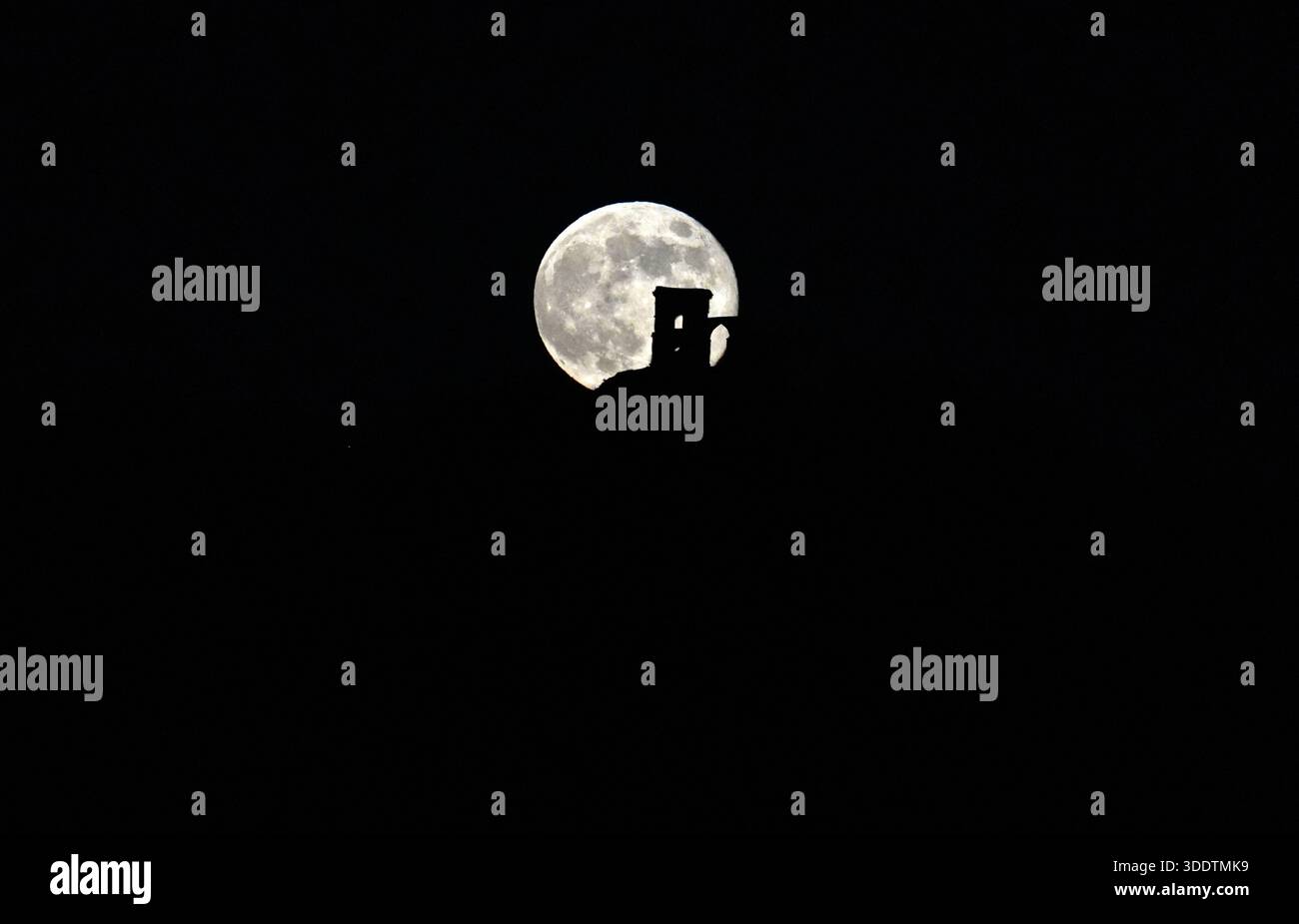 A full moon rises behind the mock ruined castle folly at Mow Cop on the ...