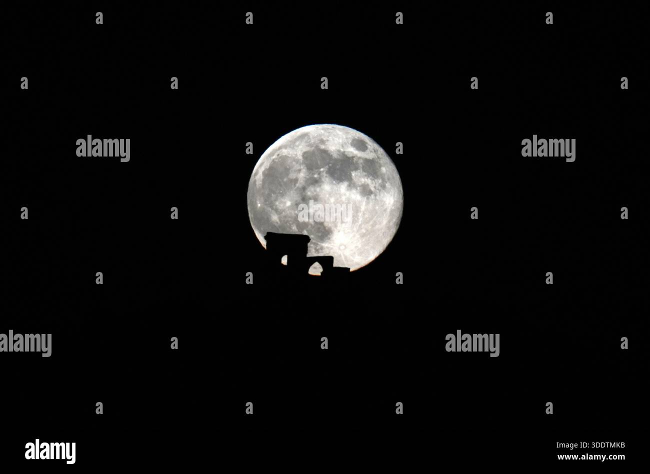 A full moon rises behind the mock ruined castle folly at Mow Cop on the ...