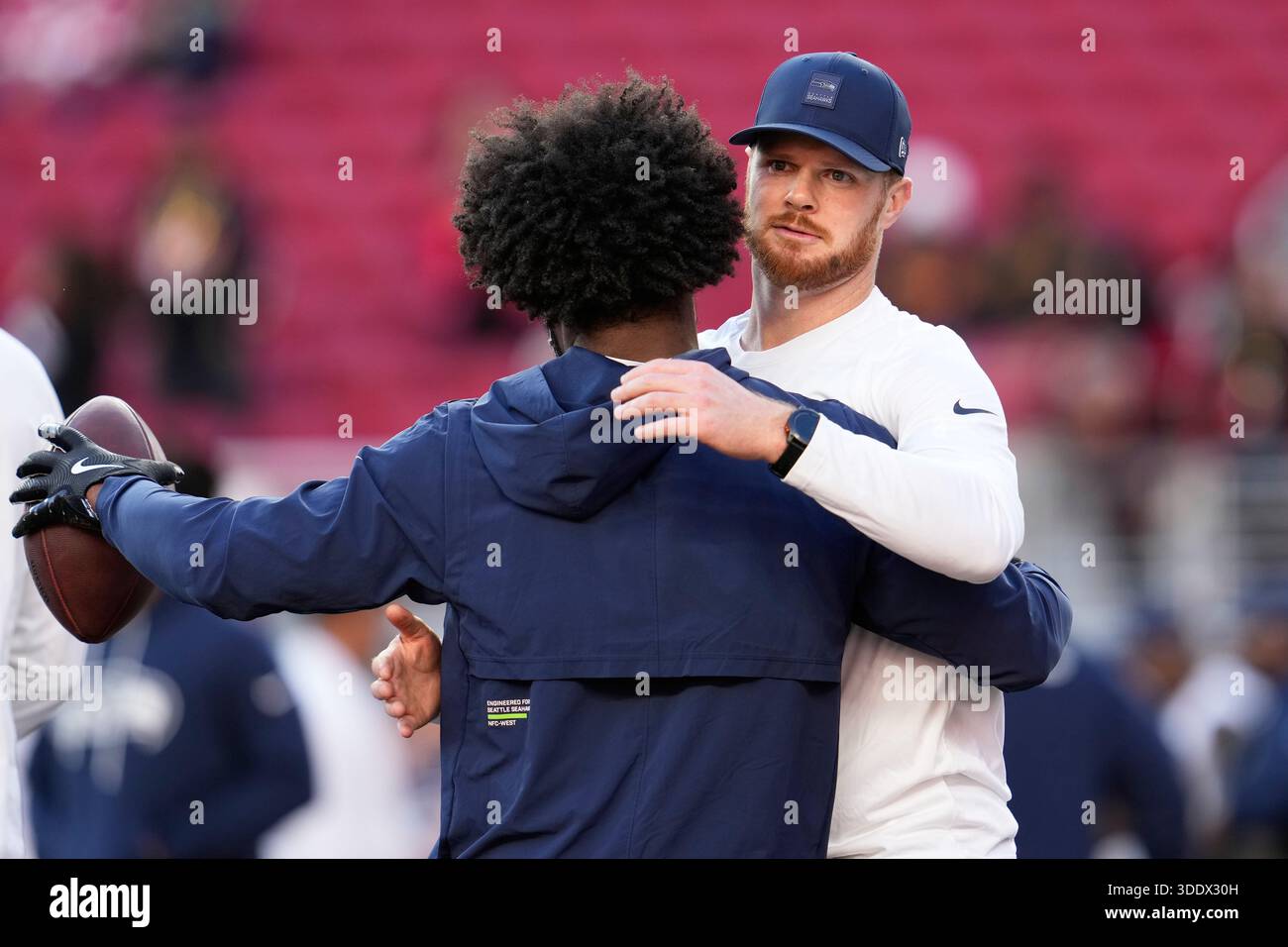 Seattle Seahawks quarterback Sam Darnold, right, greets a teammate ...