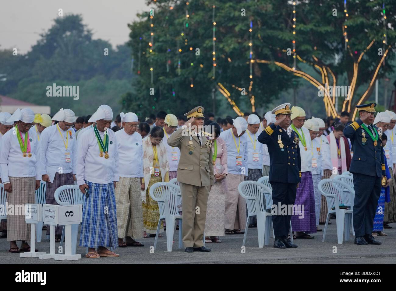 Myanmar's government officials salute at their national flag during a ...