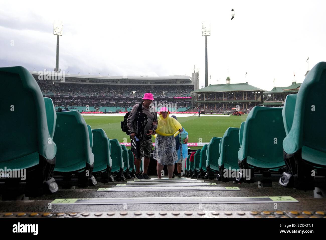 A general view as bad light and rain stops play as fans look for ...
