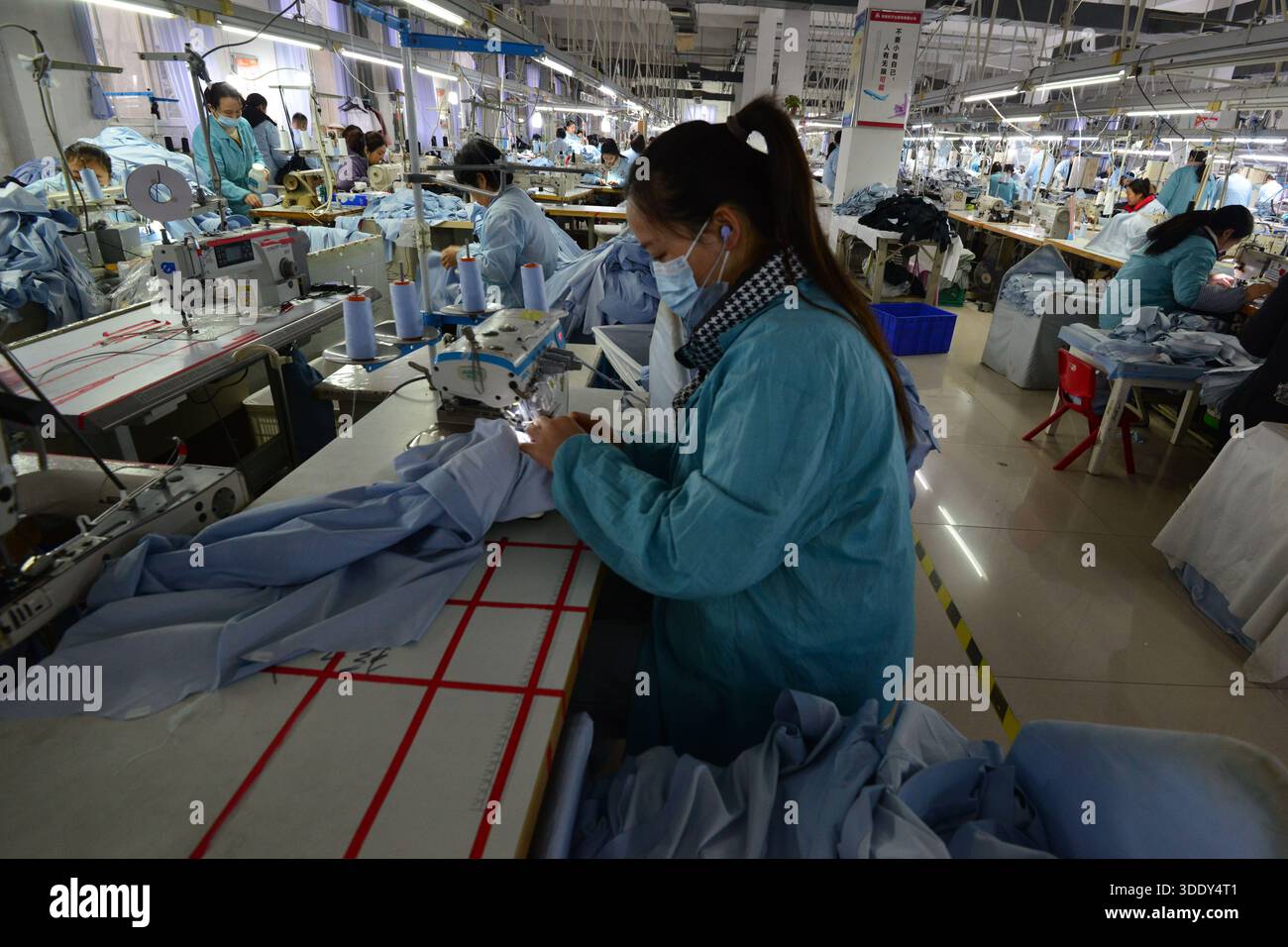 A woman works at a factory producing shirts in Fuyang in central China ...