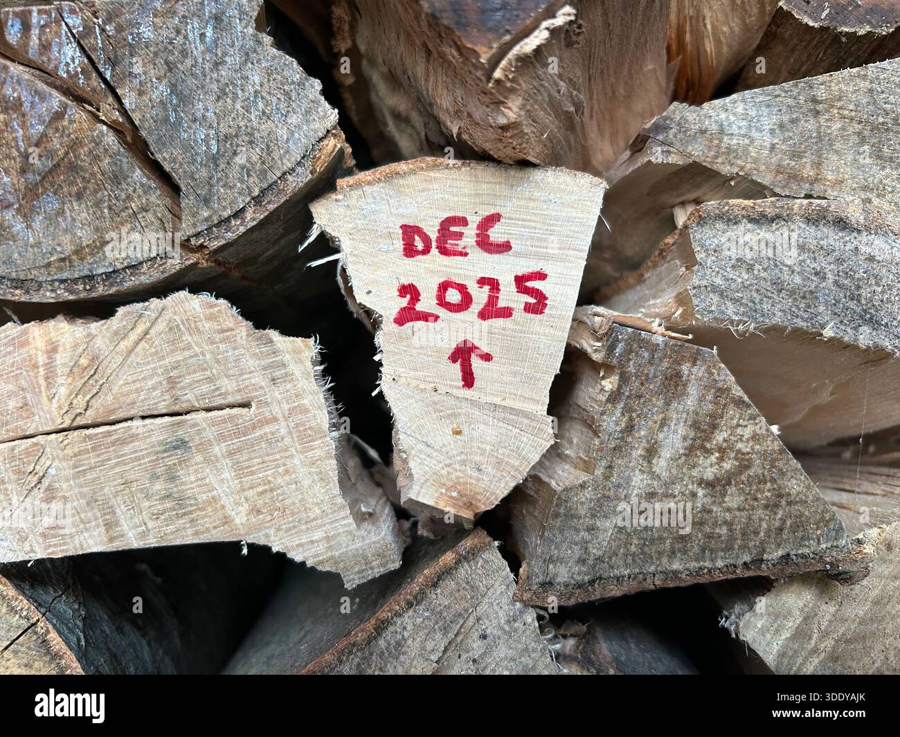Layers of split & dried logs stacked in a home-made log store, ready ...