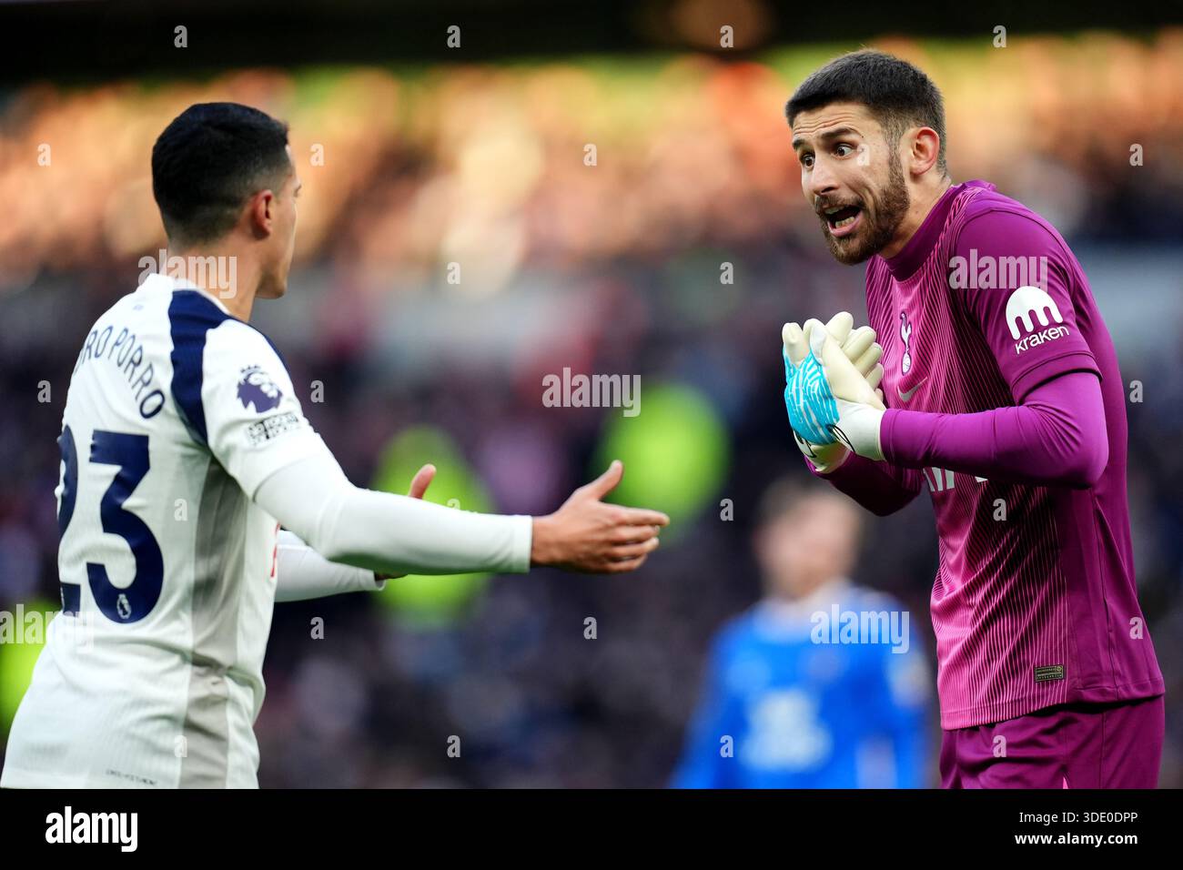 Tottenham Hotspur's Pedro Porro (left) addresses goalkeeper Guglielmo ...