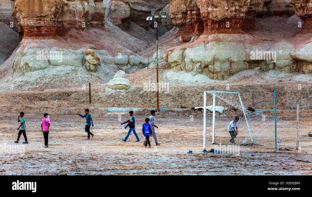 Boys playing football beneath Al Qarah Mountain, Al Ahsa Oasis, Hofuf ...
