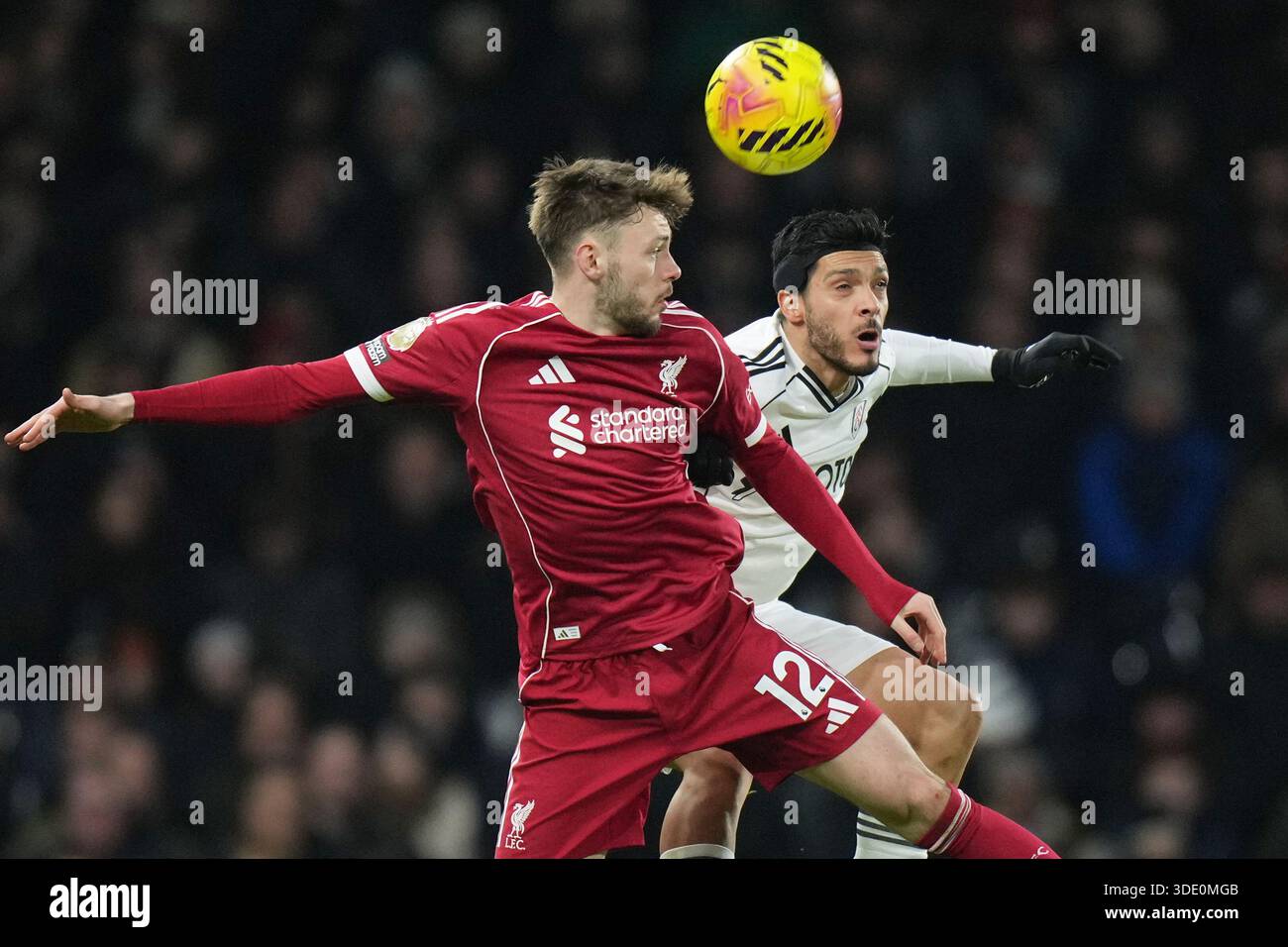 Liverpool's Conor Bradley, left, challenges for the ball with Fulham's ...