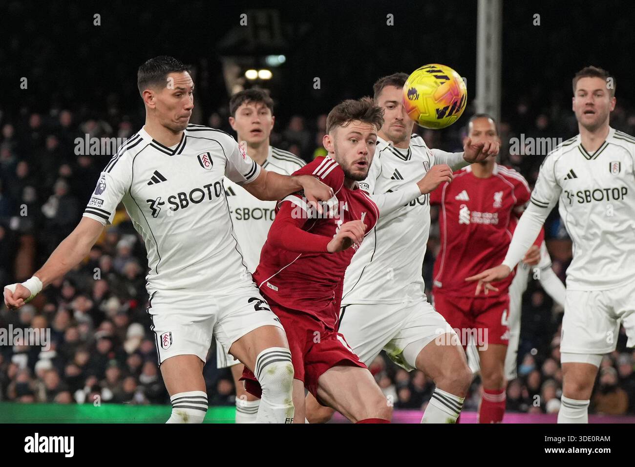 Fulham's Sasa Lukic clears the ball next to Liverpool's Conor Bradley ...