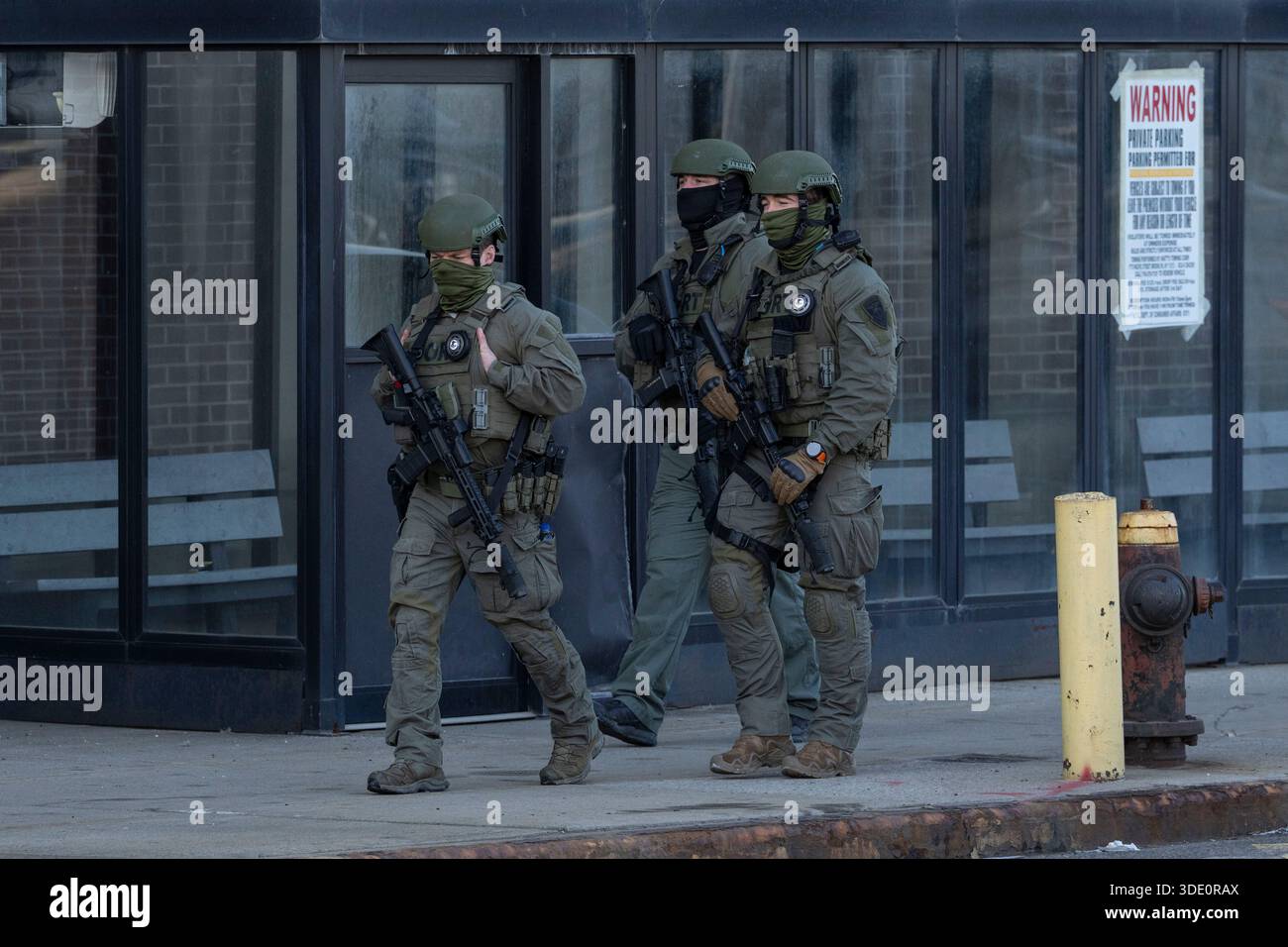 Federal officers walk around Metropolitan Detention Center on Sunday ...