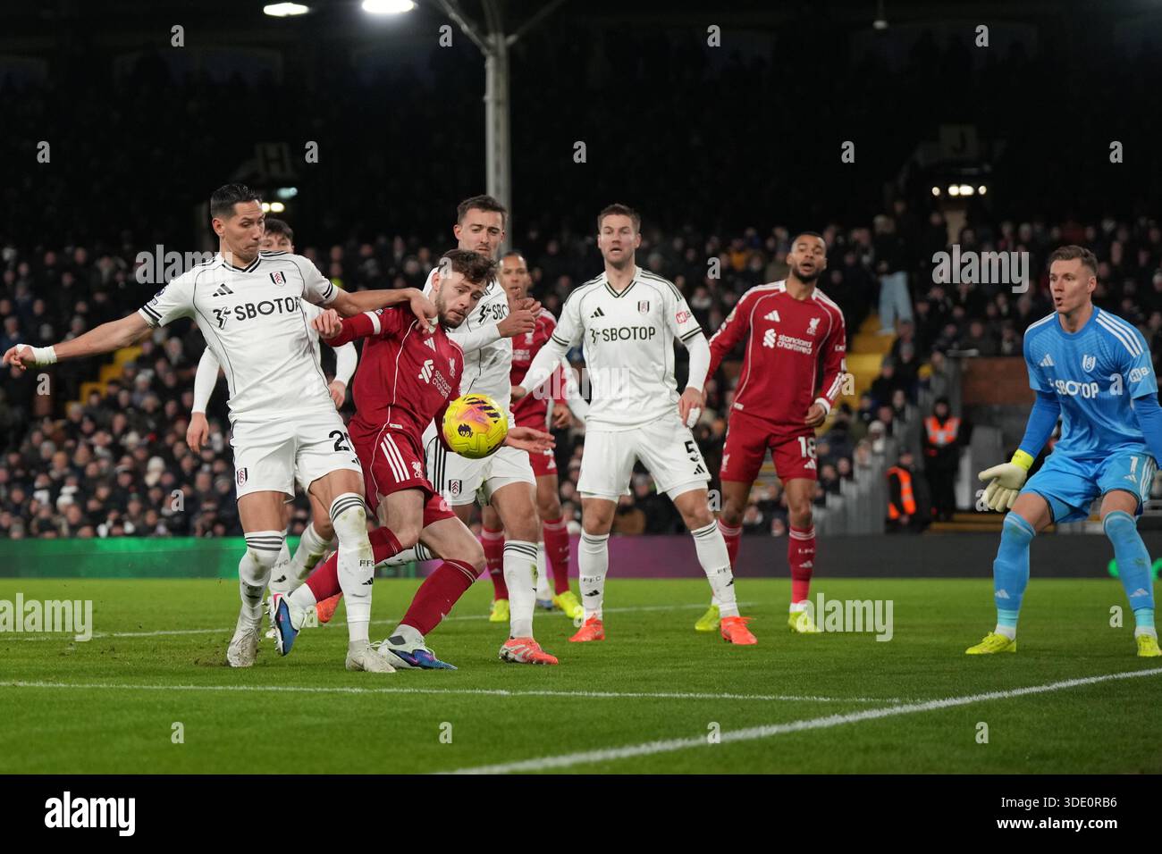 Fulham's Sasa Lukic clears the ball next to Liverpool's Conor Bradley ...