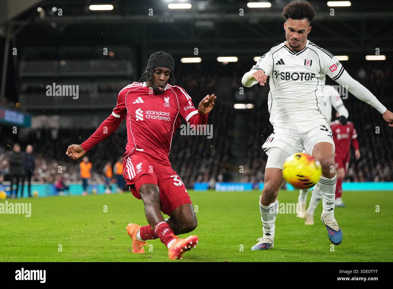 Liverpool's Jeremie Frimpong, left, challenges for the ball with Fulham ...