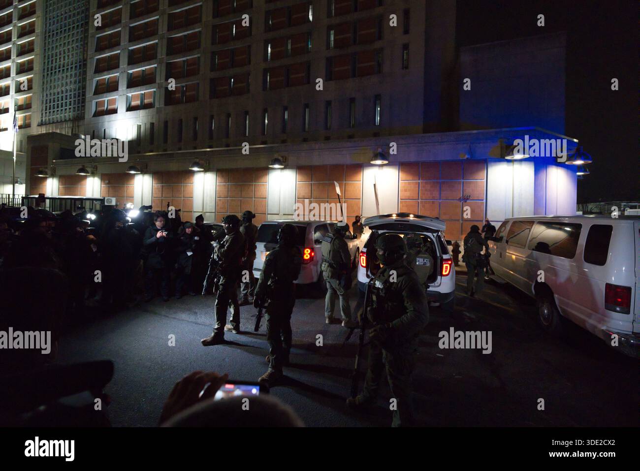 A group of heavily armed police officers stand outside a building at ...
