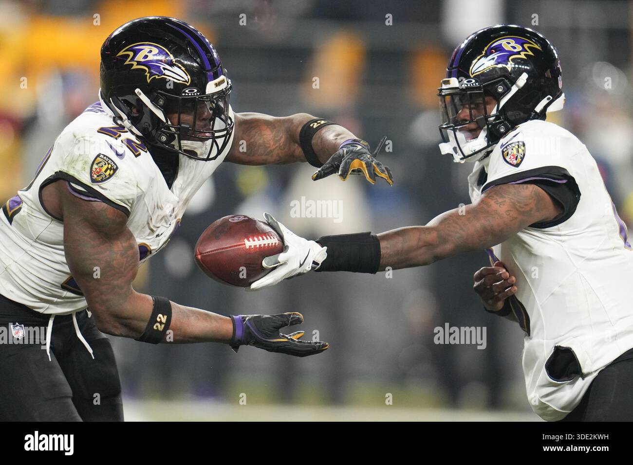 Baltimore Ravens quarterback Lamar Jackson, right, hands the ball off ...