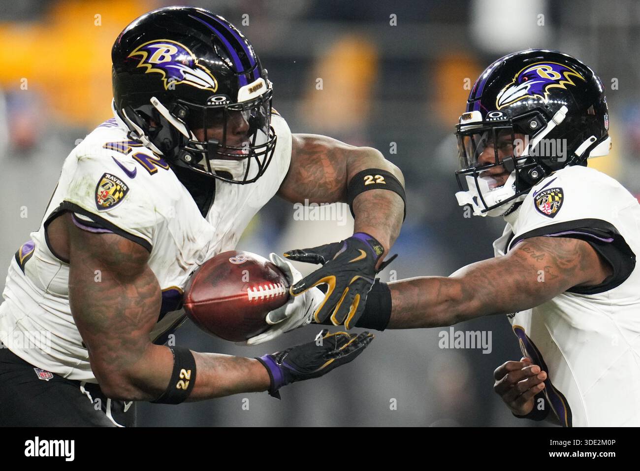 Baltimore Ravens quarterback Lamar Jackson, right, hands the ball off ...