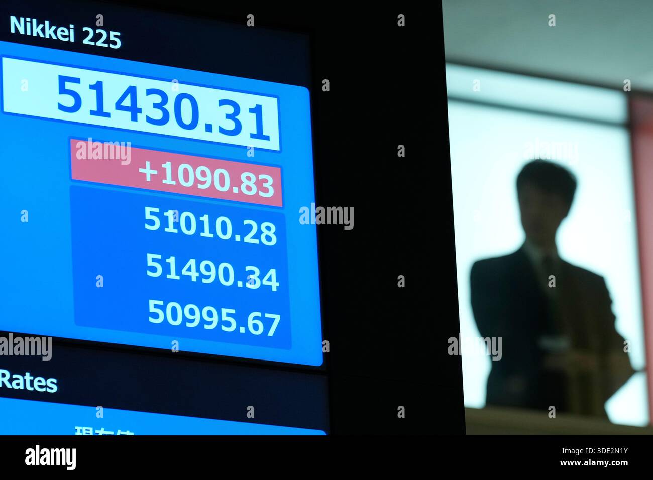 A staff stands near a monitor showing Nikkei 225 index after a ceremony ...