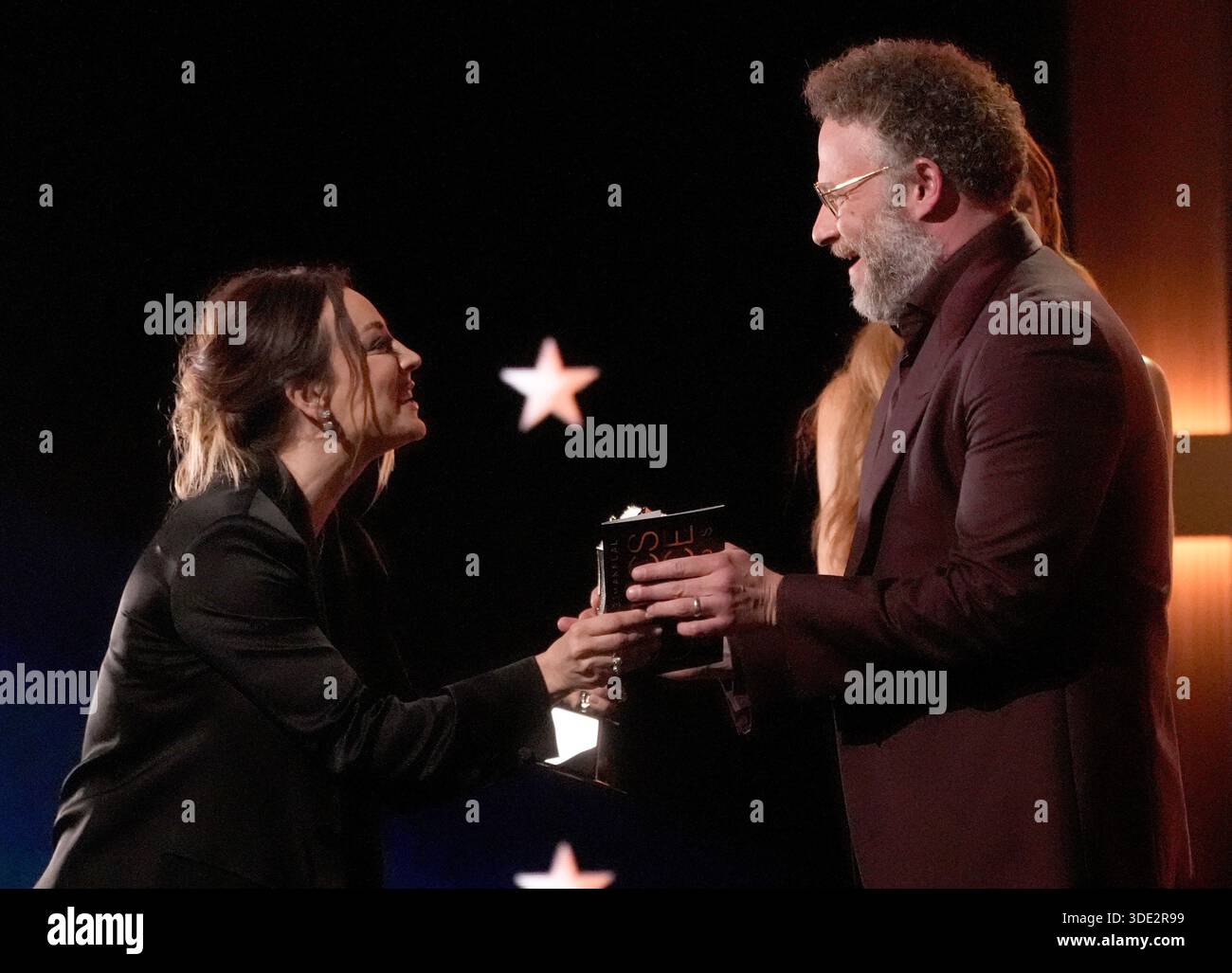 Kaley Cuoco, left, presents Seth Rogen the award for best comedy series ...