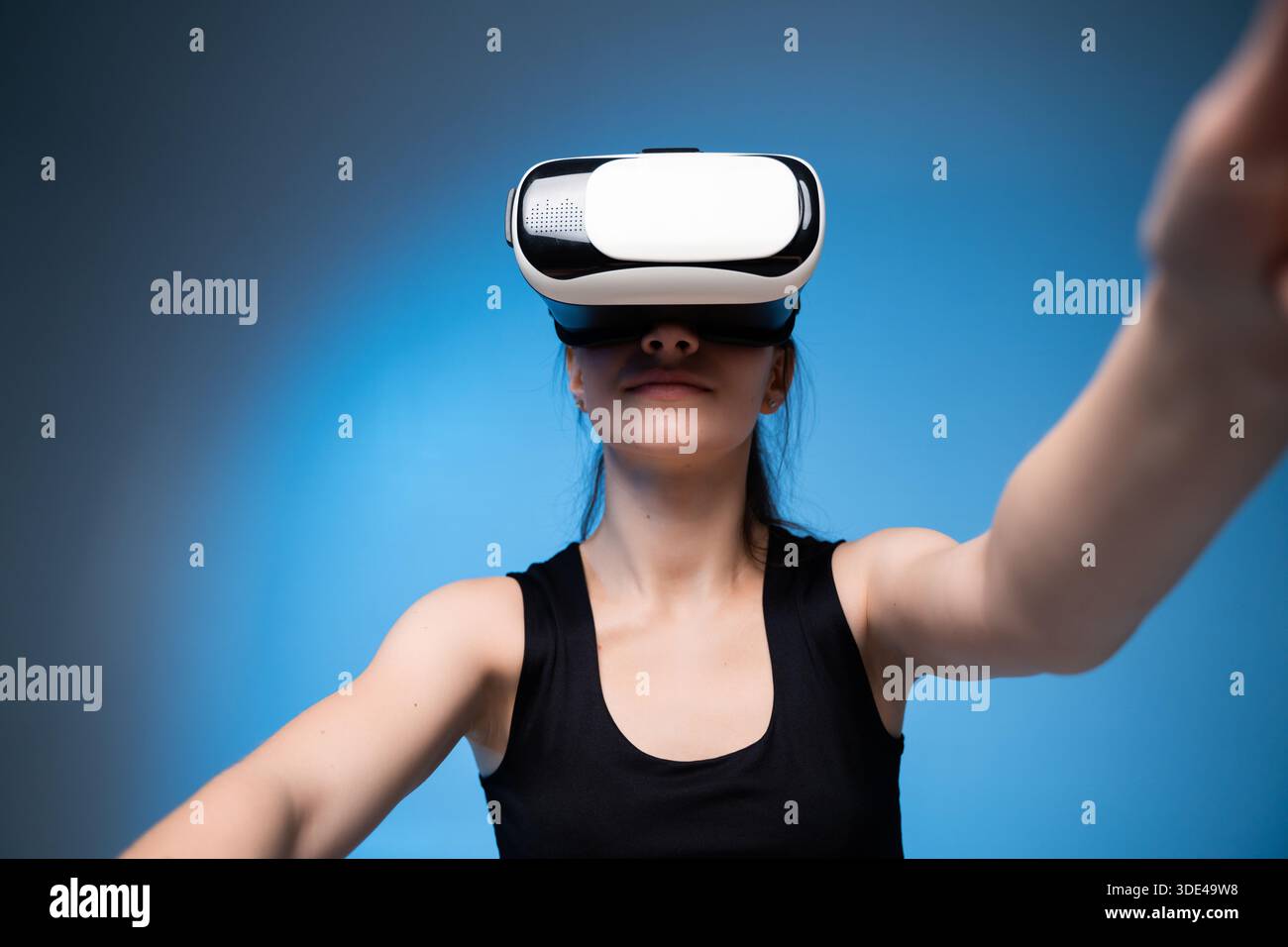 Young woman using a virtual reality headset and extending her arms ...