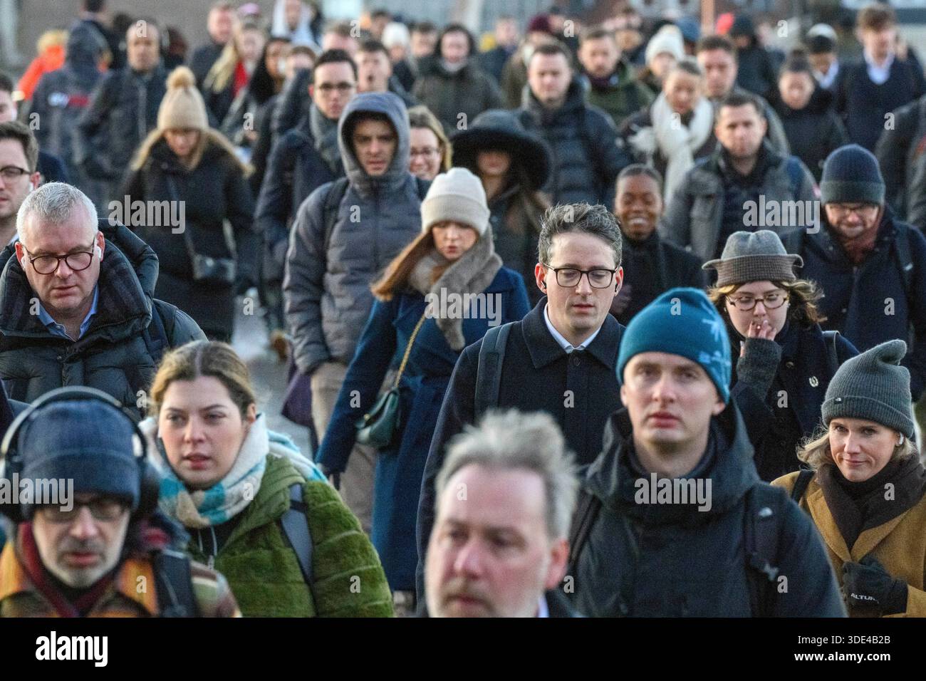05/01/2026. London, UK. Commuters walk across London Bridge during the ...