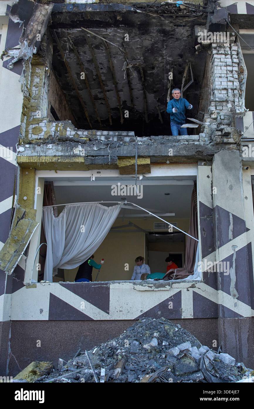 Medical workers remove the debris in a damaged private clinic after ...