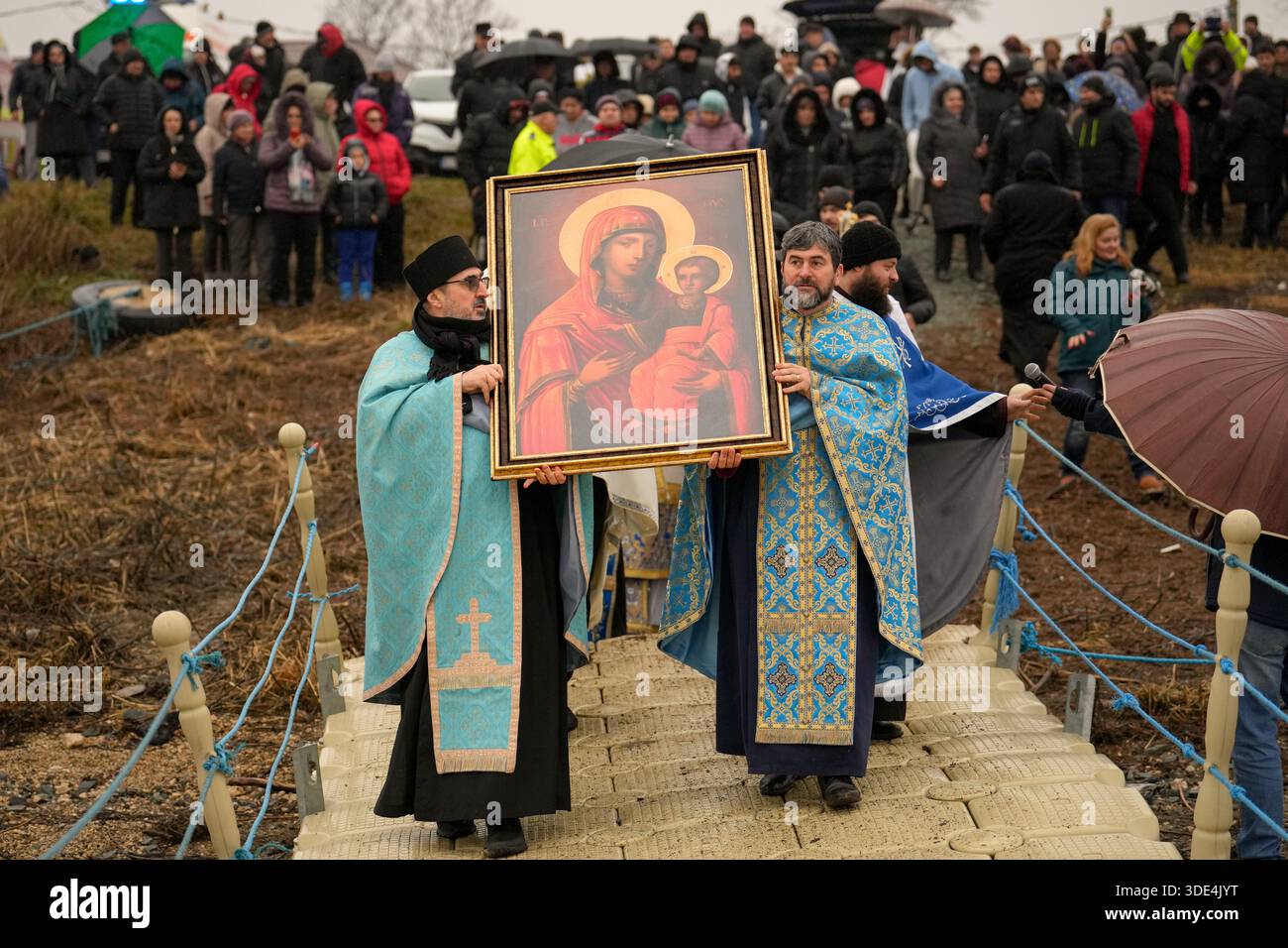 Clerics carry an icon on a bank of the river Danube during a religious ...