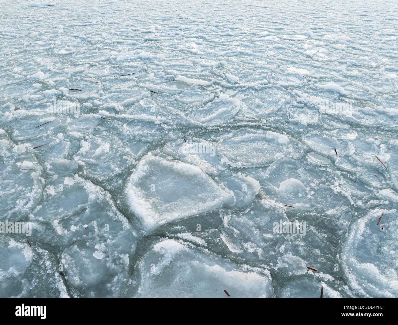Aerial drone shot of frozen Baltic Sea water with cracked ice floes and ...
