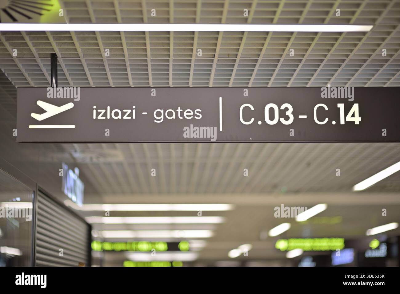 Airport sign showing gate numbers in both English and Serbian language ...