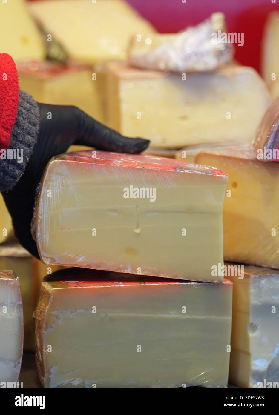 PRODUCTION - 03 January 2026, Hamburg: An employee puts back a cheese ...