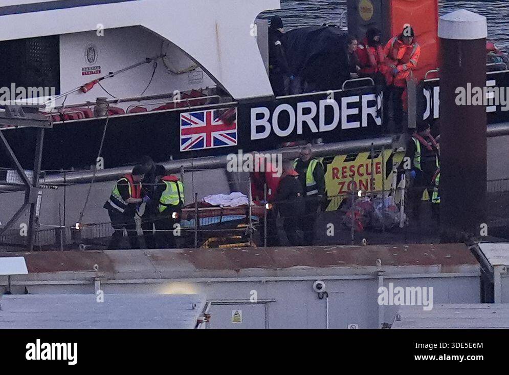 A stretcher is used as a group of people thought to be migrants are ...