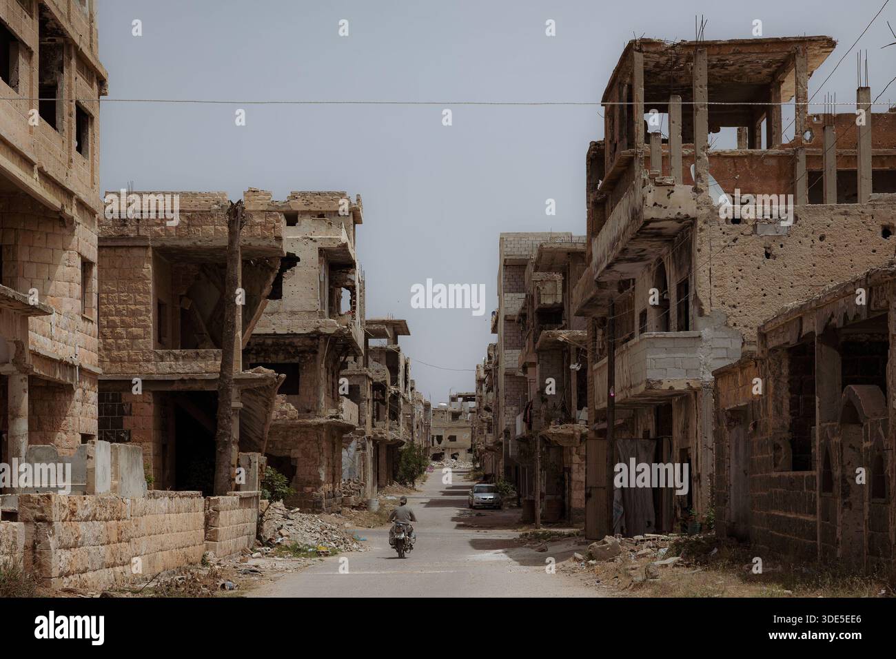 War-damaged buildings line a street in Daraa city, the birthplace of ...