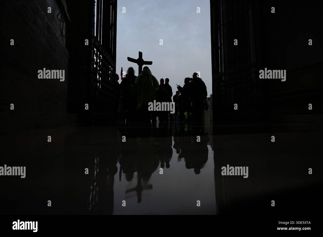 Pilgrims and faithful hold a crucifix as they arrive to St. Peter's ...