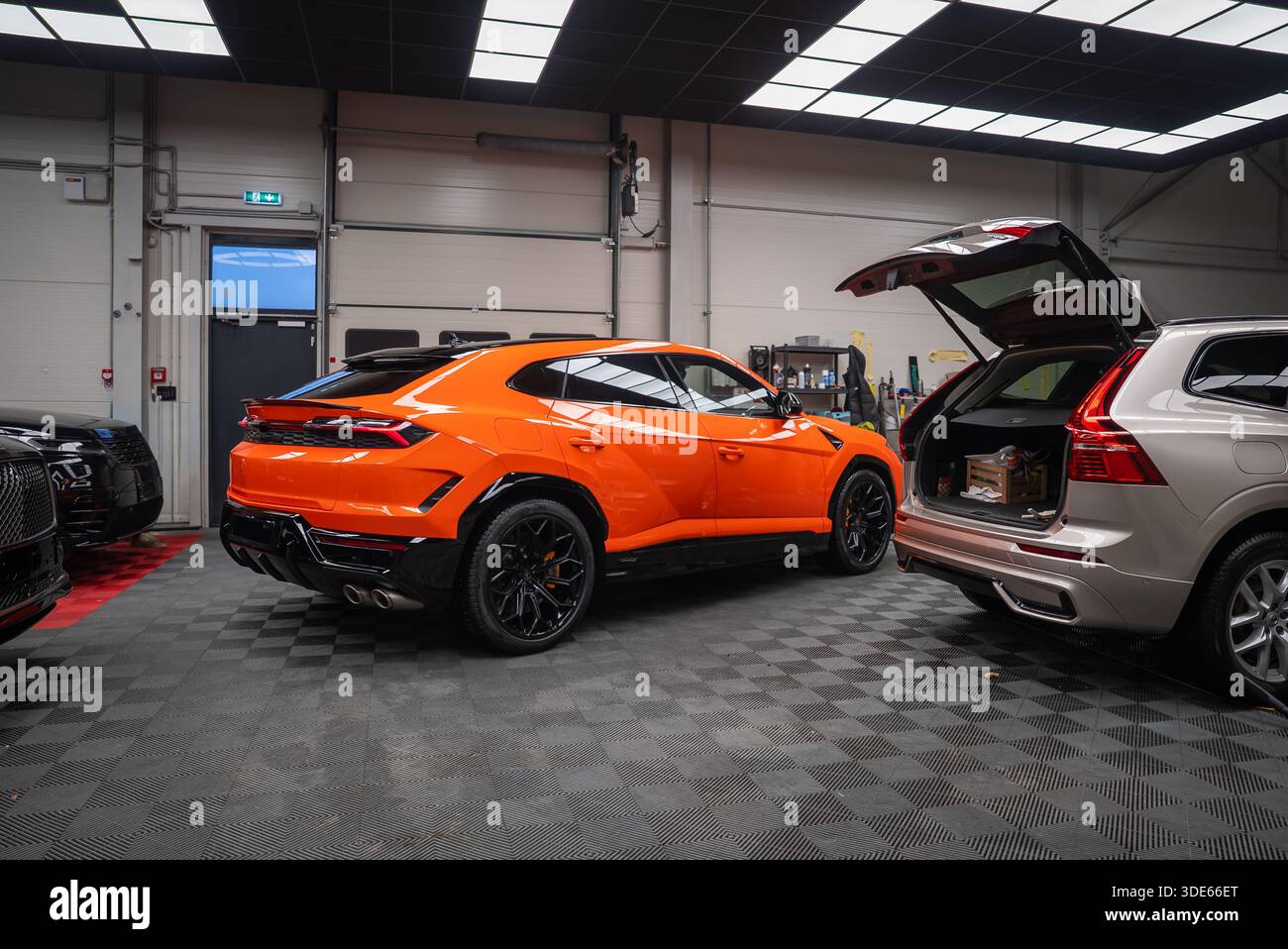 Orange Lamborghini Urus SE in a well lit automotive workshop Stock ...
