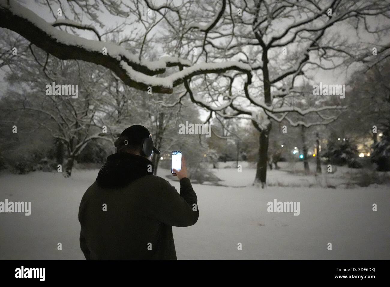 05 January 2026, Hamburg: A man uses his smartphone to photograph the ...