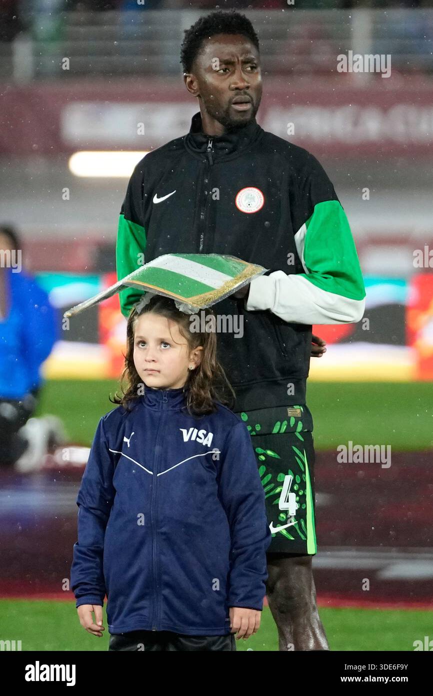 Nigeria's Wilfred Ndidi tries to protect a mascot from the rain prior ...