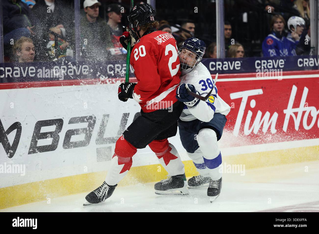 Finland forward Oliver Suvanto (38) checks Canada defenseman Keaton ...
