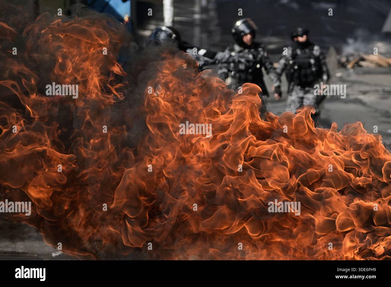Fire breaks out as police walk past during clashes with members of the ...