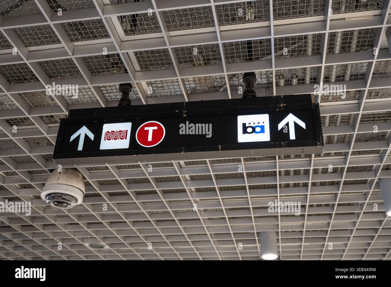 Overhead transit sign with Muni and BART logos and directional arrows ...