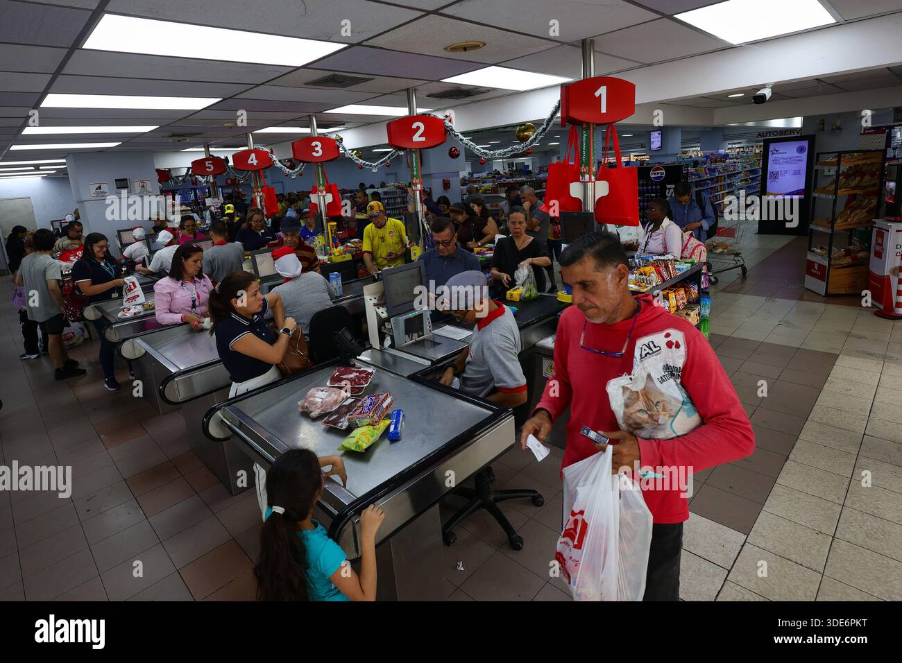 05 January 2026, Venezuela, Caracas: People buy food in a supermarket ...