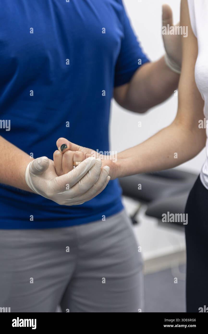 Physiotherapist and female patient get manual wrist and hand assessment ...