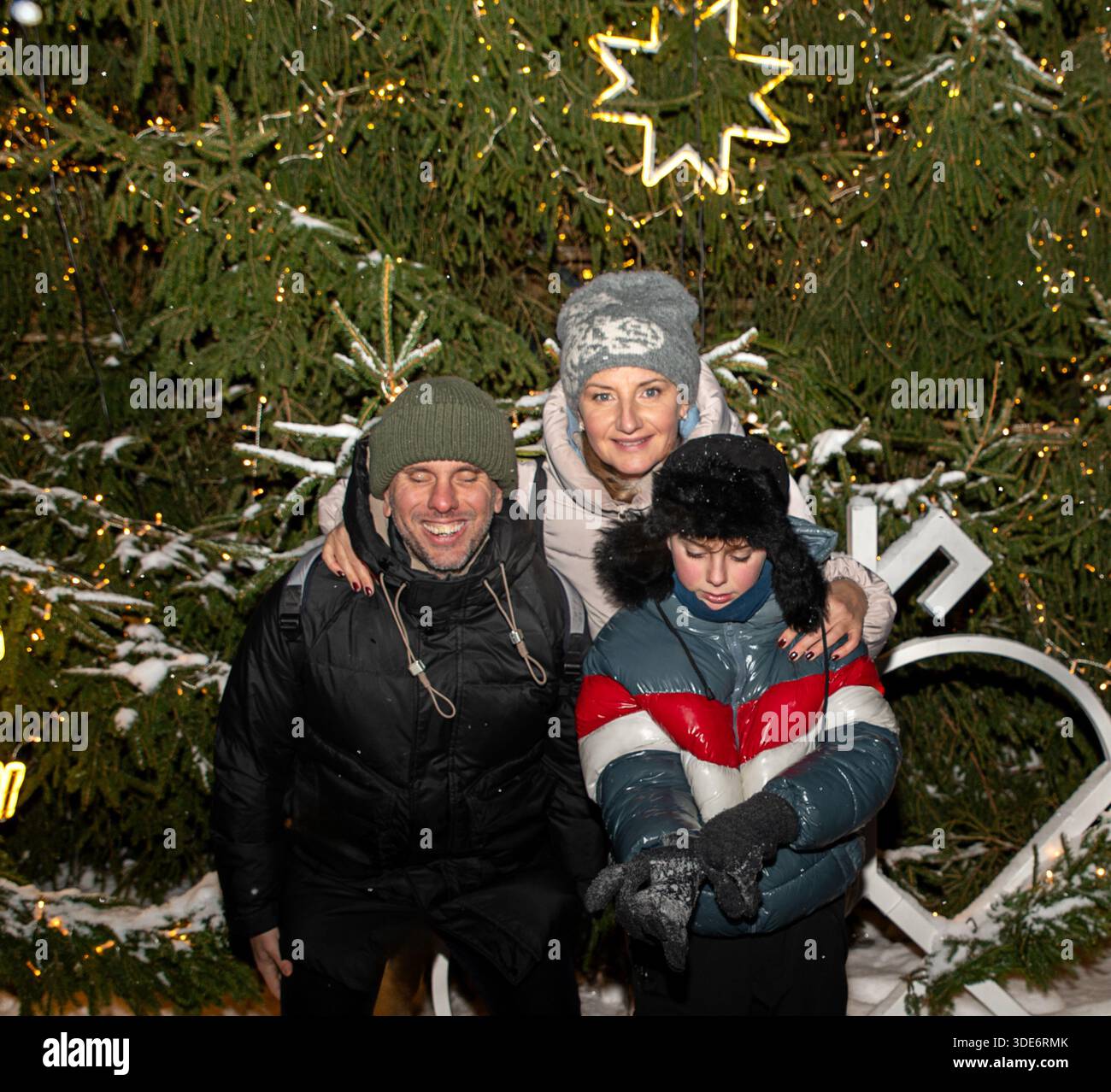Smiling Family with Parents and 10-Year-Old Son Under a Snow-Covered ...